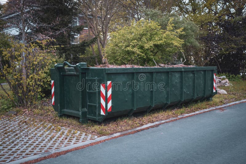 A Large Green Container is Completely Filled with Leaves Stock Photo ...