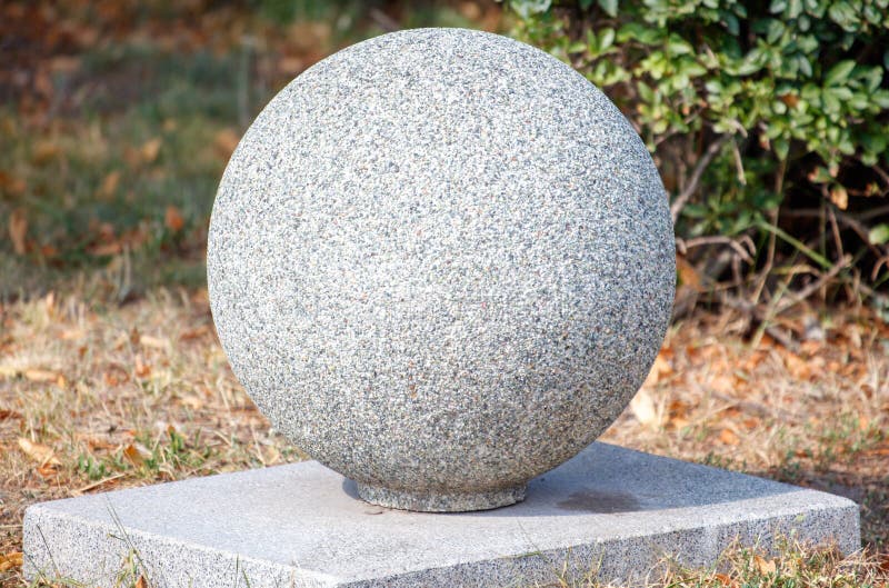 A Large Grey Stone Ball Sits on a Concrete Base Stock Photo - Image of ...