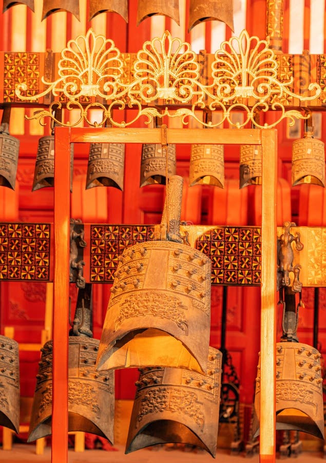 A Large Group of Bells Hanging from a Metal Rack with Other Bells ...