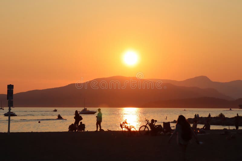 Large Group of People Gathered on the Beach, Facing the Sunset Stock ...