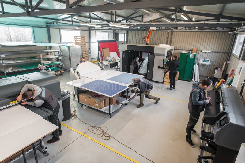 Two Technicians Glue Poster To Foam. Semi Automatic Gluing Machine ... Two Technicians Glue Poster To Foam. Semi Automatic Gluing Machine ...