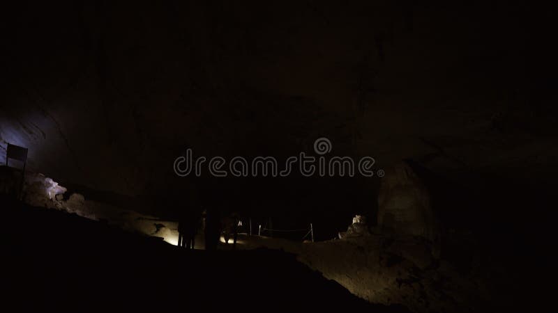 Group of People Exploring Dark Cave with Flashlights - Guided Tour ...