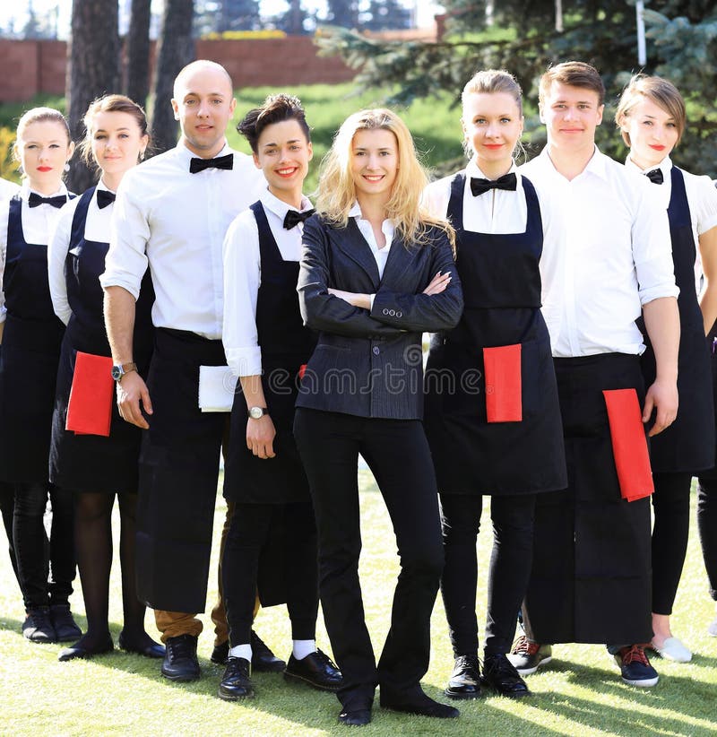 A Large Group of Waiters and Waitresses in the Open Air Stand One after ...