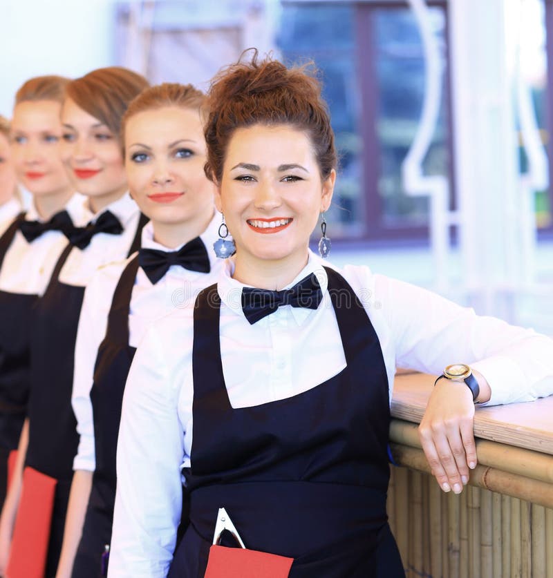 A Large Group of Happy and Emotional Waiters Standing in a Row Behind ...