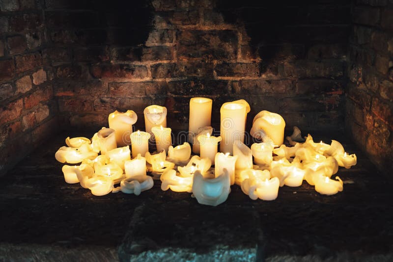 Large Group of White Burning Candles in Brick Fireplace. Candles of ...