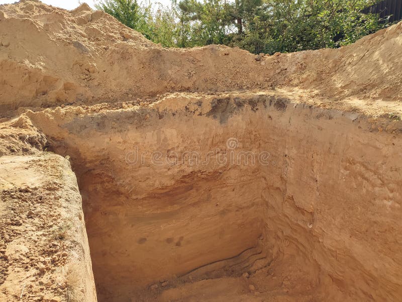Digging the Pit Foundation a Hole with Excavator at the Construction ...