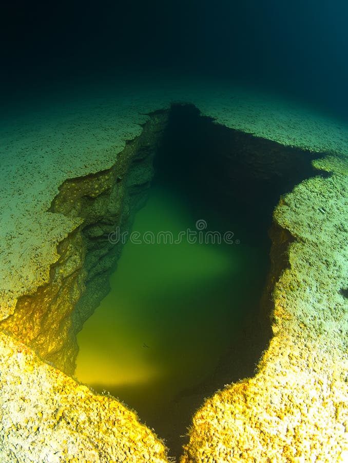 A Large Hole in the Ocean Floor with a Small Pool of Water Stock Photo ...