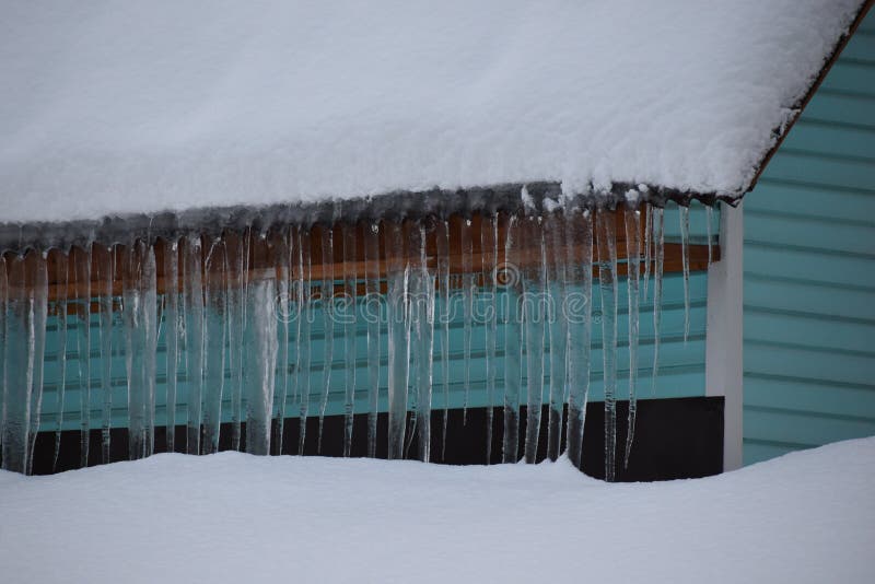 Large Ice Icicles Hang from Roof. Ice Falling Hazard Stock Photo ...
