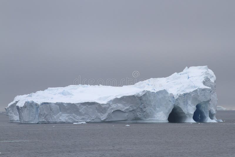 Large Iceberg with Several Caves Stock Photo - Image of cold, clear ...