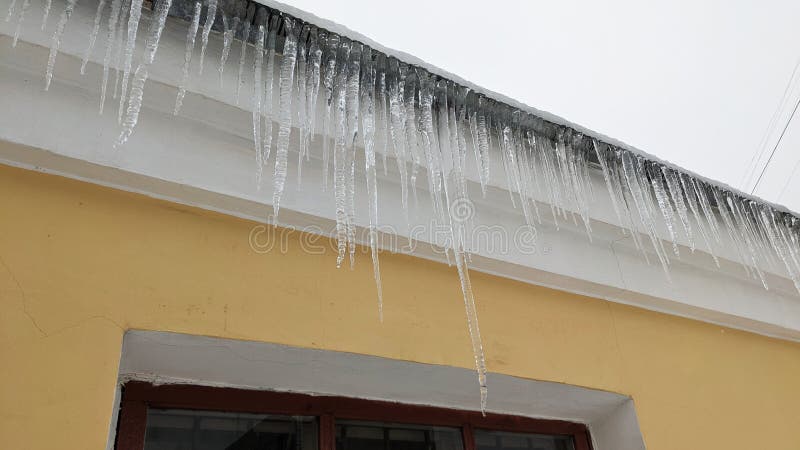 Large Icicles Hang from the Roof of the House. Danger of Falling Ice ...