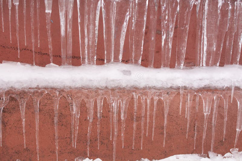 Large Icicles on a Red Background. Winter and Frosts Stock Image ...