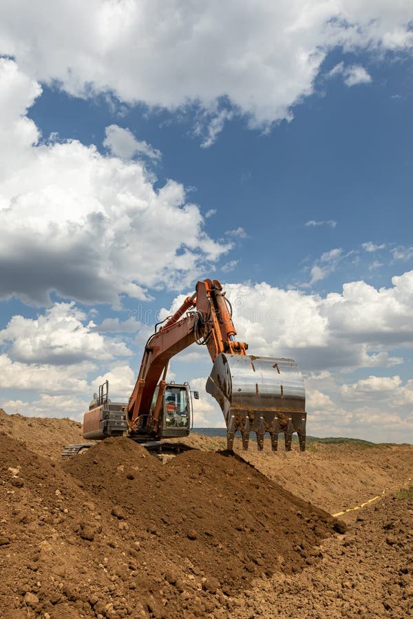 A Large Industrial Excavator Work on the Construction Site. Cloudy Sky ...
