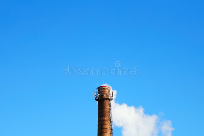 A Large Industrial Smoke Stack Rises into the Clear Blue Sky, Providing ...