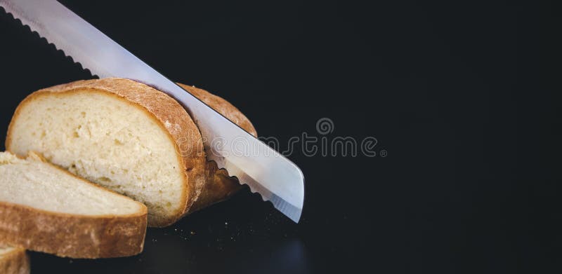 A Large Knife Cuts Thin Pieces of White Bread from a Rectangular Loaf ...