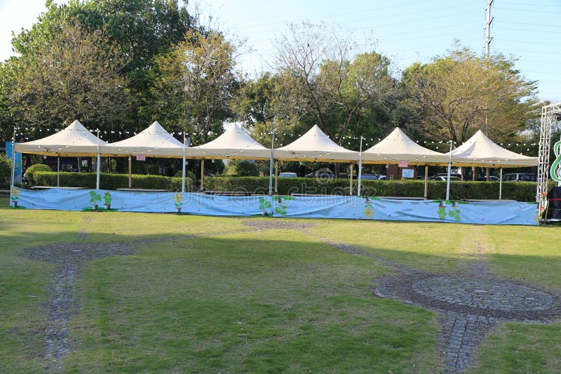 A Large Lawn with Three or Four Canopy Tents, White and Blue Canopies ...
