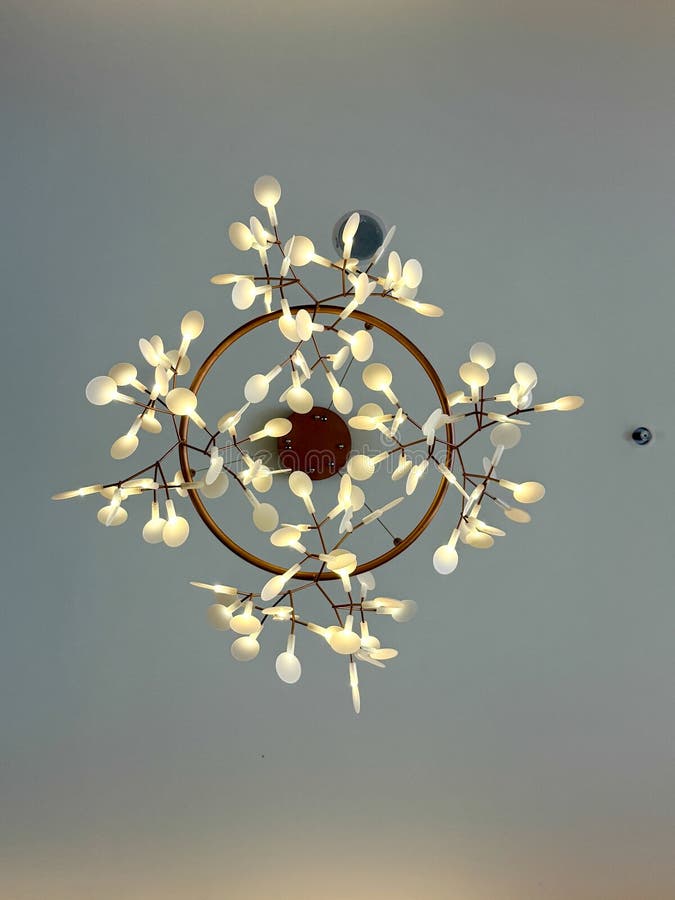 A Large Light Fixture with Many Small Lights Hanging from it Stock ...