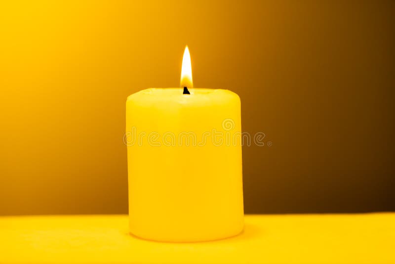 Large Lighted Candle on a Warm Yellow Background Stock Photo - Image of ...