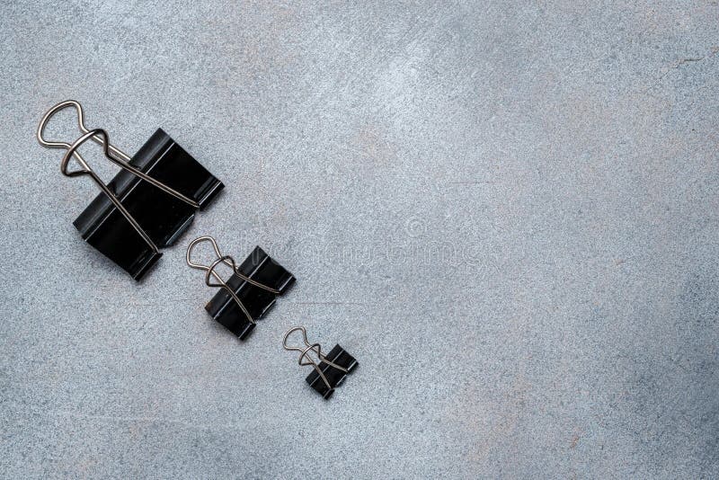 Large, Medium and Small Paper Clip on an Abstract Gray Background. View ...