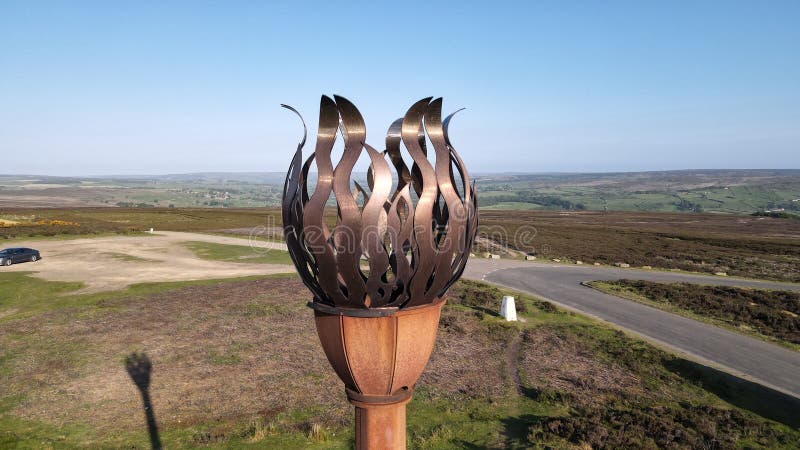 Large Metallic Sculpture of a Torch is Prominently Displayed Atop a ...