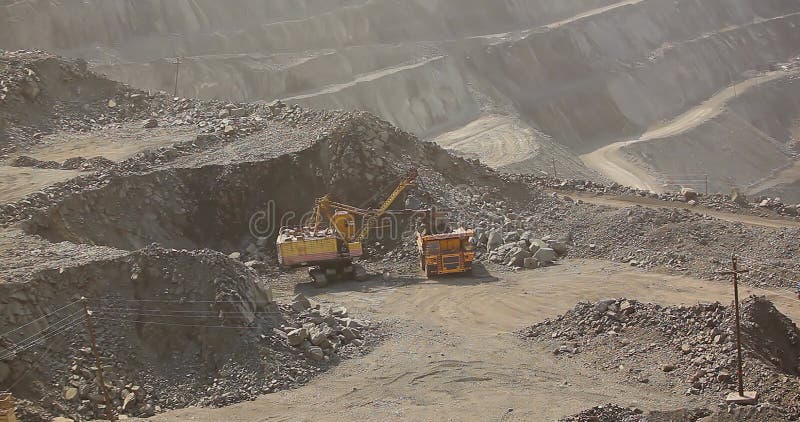 A Large Mining Excavator is Loading a Mining Truck in an Iron Ore ...