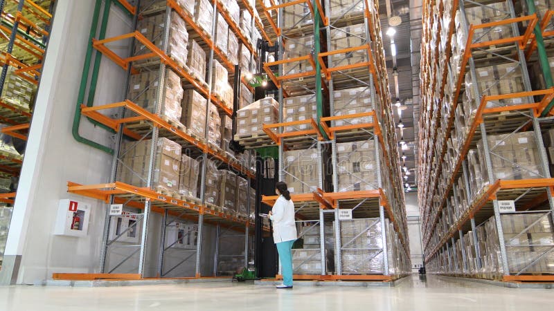 Large Modern Warehouse with Forklifts. Warehouse Worker Taking Package ...