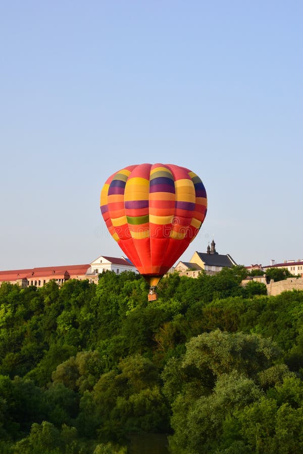 A Large Multi-colored Balloon Flies Very Low Over the River and between ...