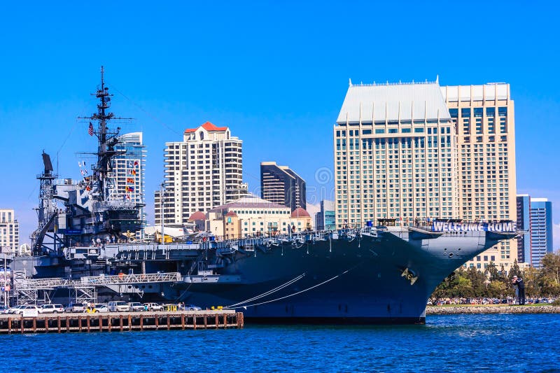 A Large Navy Ship is Docked in Front of a Large Hotel Stock Photo ...