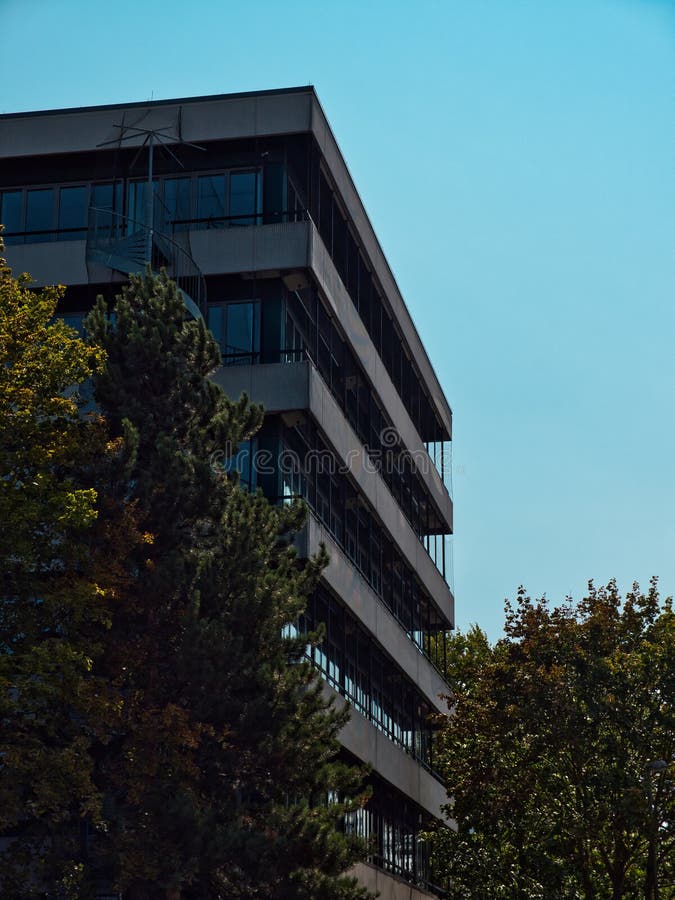 A Large Office Building with Clear Blue Sky and Trees Stock Photo ...