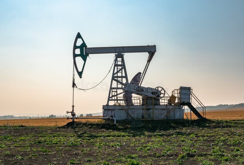 A Large Oil Pump Jack Operates in an Open Field, Extracting Crude Oil ...