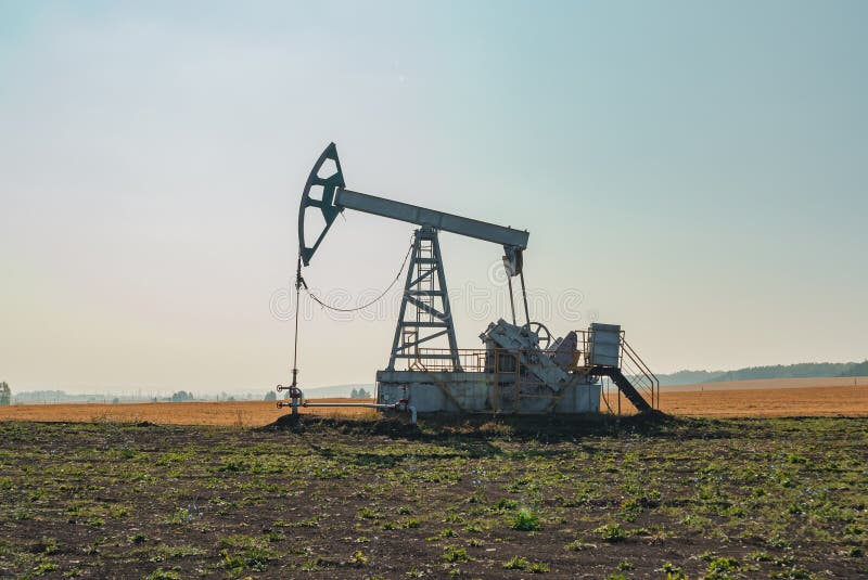 A Large Oil Pump Jack Operates in an Open Field, Extracting Crude Oil ...