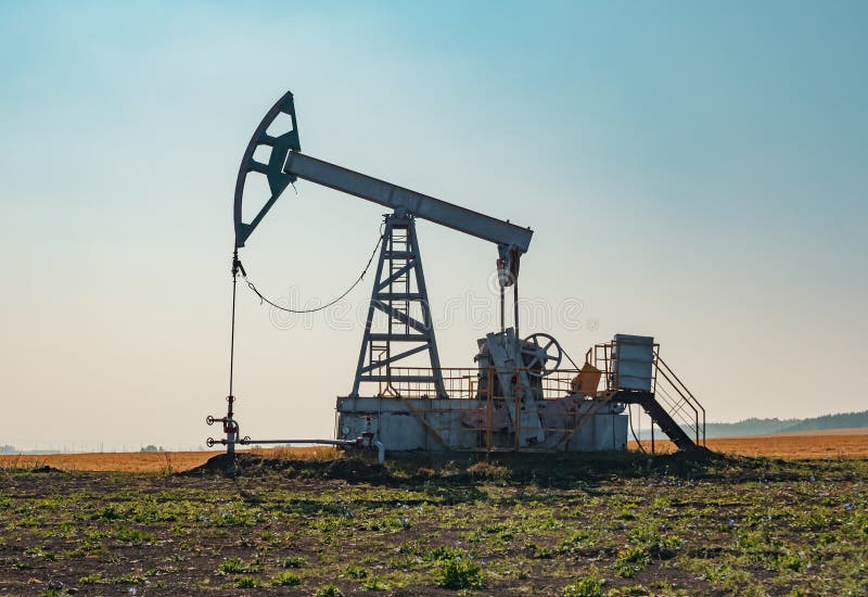 A Large Oil Pump Jack Operates in an Open Field, Extracting Crude Oil ...