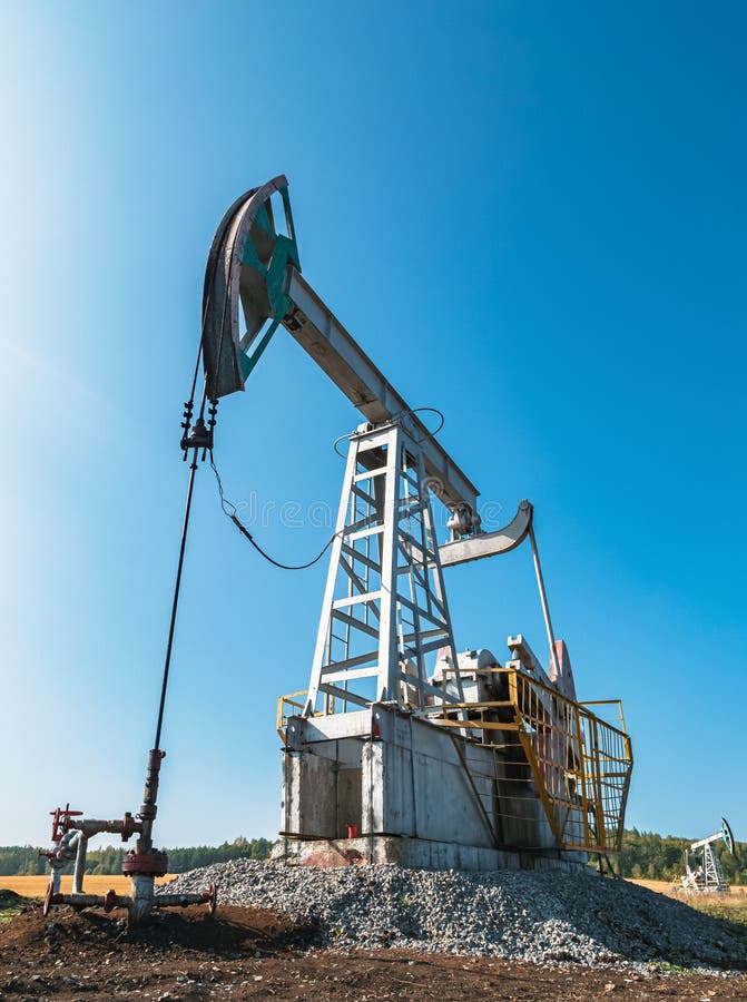 A Large Oil Pump Jack Operates in an Open Field, Extracting Crude Oil ...