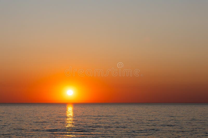 A Large Orange Sun Setting Over a Calm Sea. Stock Image - Image of ...