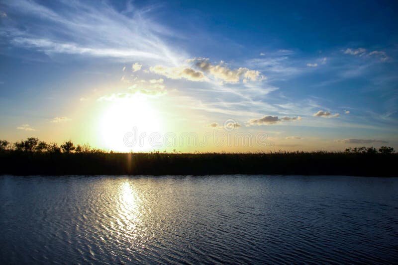 Large Orange Sun Setting in the Water Stock Image - Image of cypress ...
