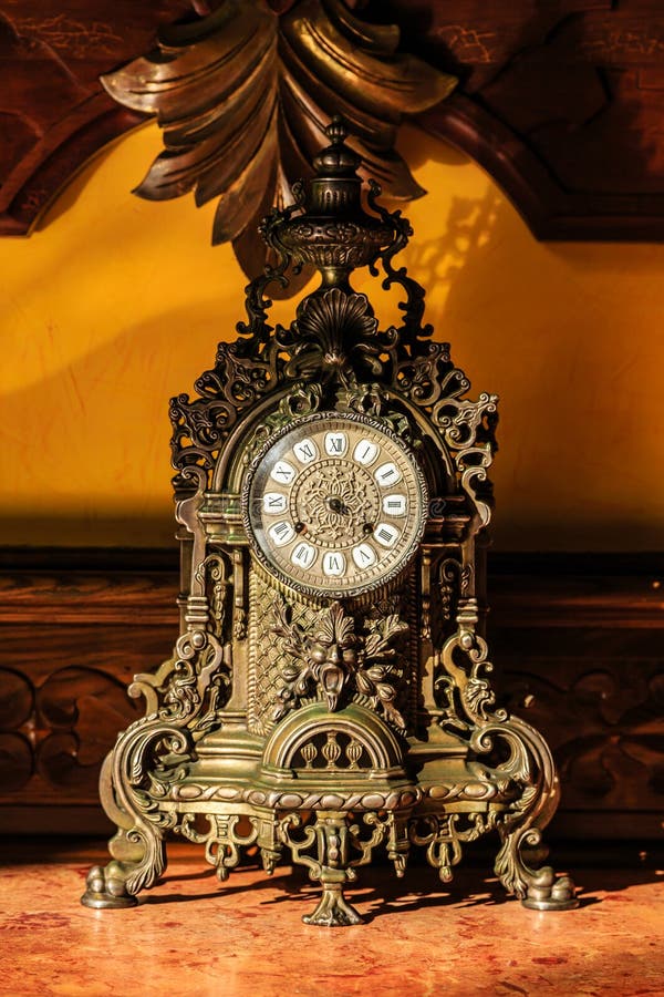 A Large, Ornate Clock with a Gold Frame Sits on a Table Stock Image ...