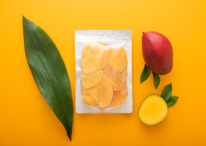 Large Pack of Dried Mango Slices with Leaf and Raw Mango on Yellow ...