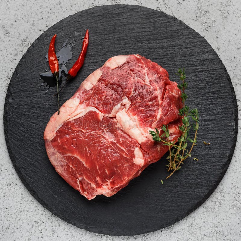 Large Piece of Raw Beef Chop on Black Board, Top View Stock Image ...