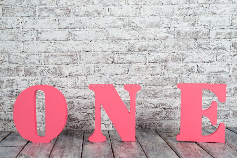 Large Pink Letters ONE Against a White Brick Wall. Stock Image - Image ...