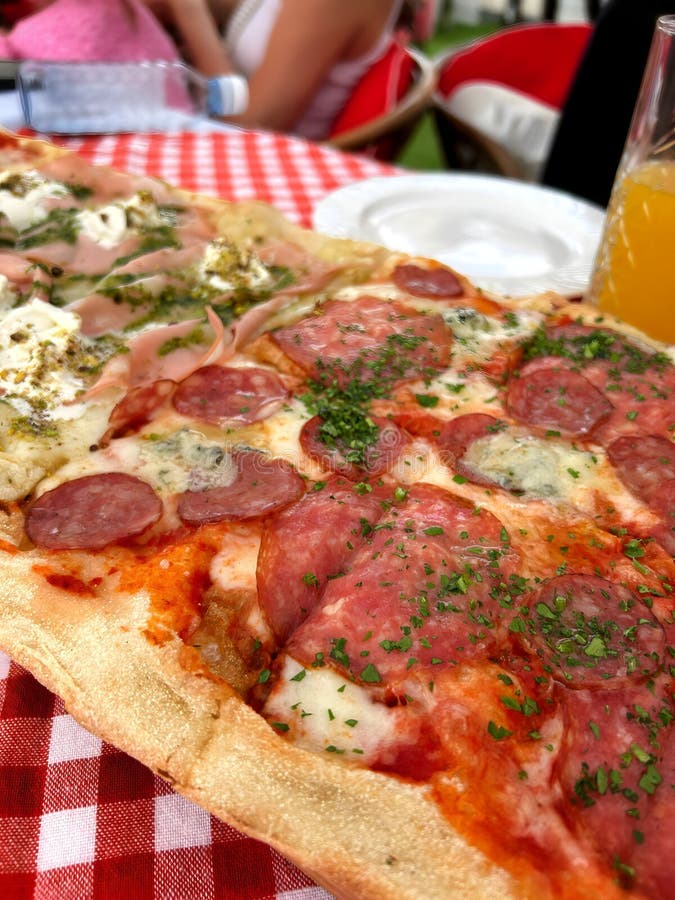 A Large Pizza with Sausage, Cheese and Herbs Lies on a Table Stock ...