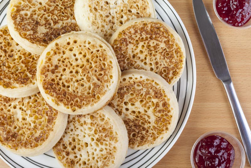 Freshly Toasted Crumpets with Butter and Jam on Country Table Stock ...