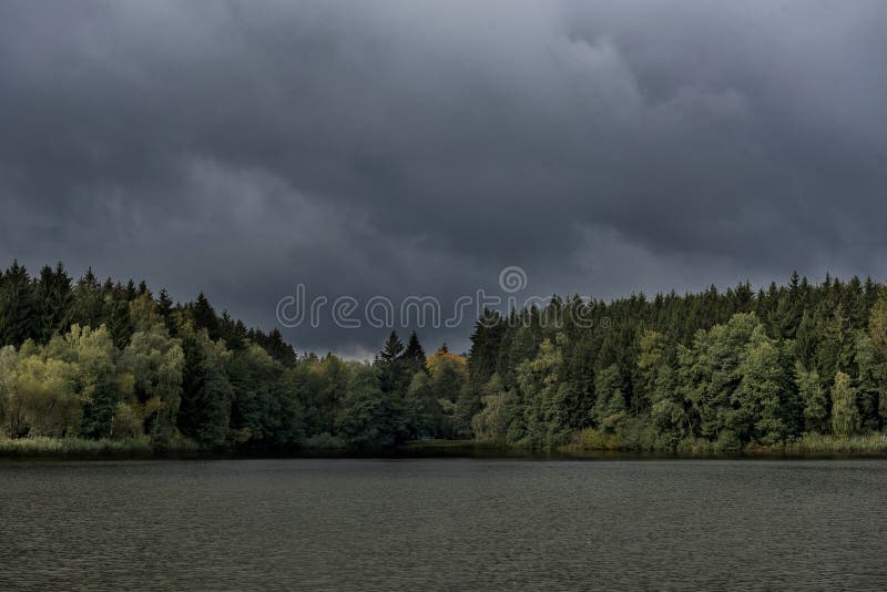 A Large Pond of Dark Coniferous Forest with Dark, Terrifying Clouds ...