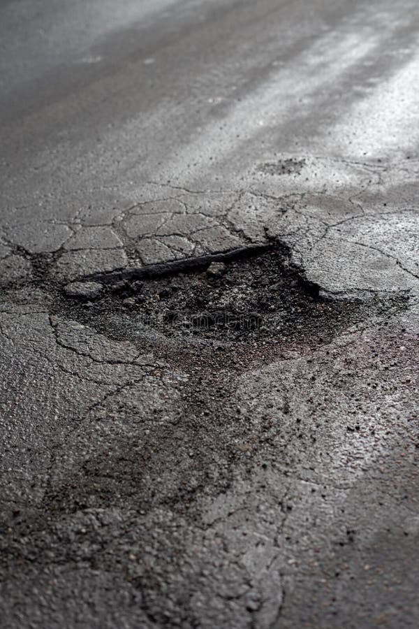Large Pothole in the Asphalt on a Road after Frost in Winter Vertical ...
