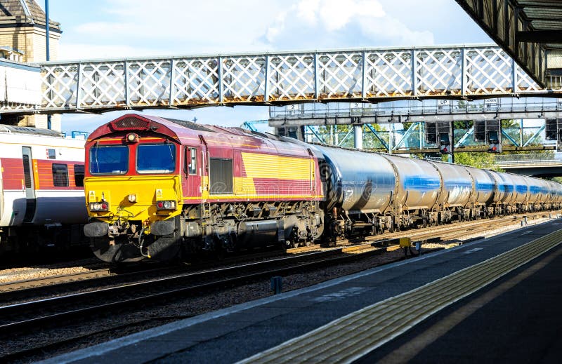 A Large and Powerful Freight Train Passing by a Station Platform ...