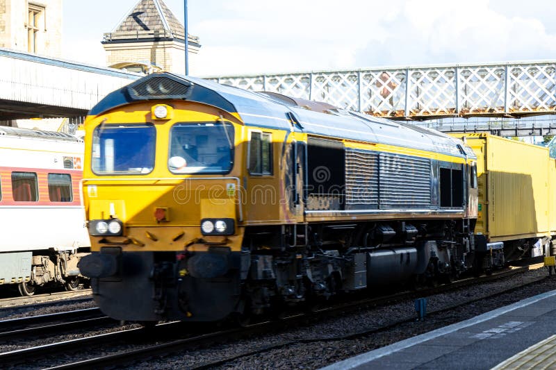 A Large and Powerful Freight Train Passing by a Station Platform ...