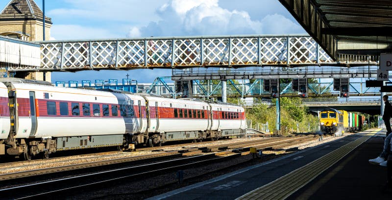 A Large and Powerful Freight Train Passing by a Station Platform ...