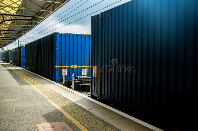 A Large and Powerful Freight Train Passing by a Station Platform ...
