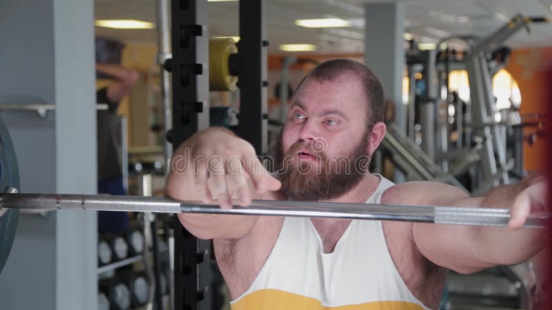A Large and Powerful Weightlifter Bites the Barbell Angrily before ...