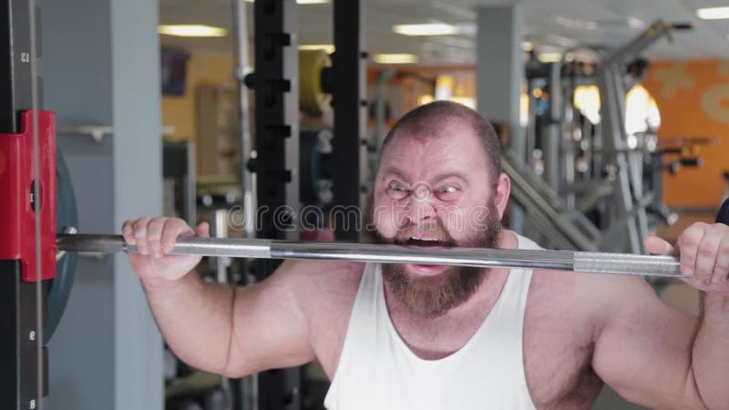 A Large and Powerful Weightlifter Bites the Barbell Angrily before ...