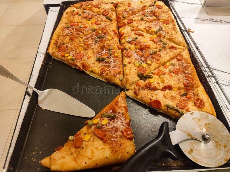 Large Rectangular Pizza with Colorful Toppings, Partially Sliced and ...