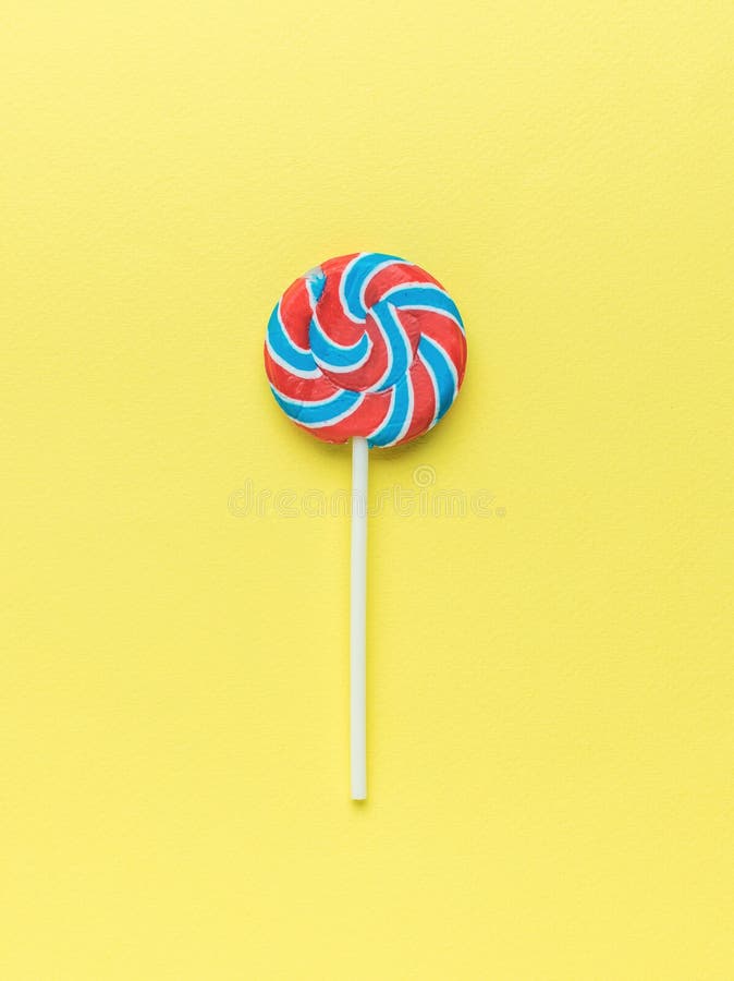 A Large Red and Blue Lollipop on a Yellow Background. the Concept of ...